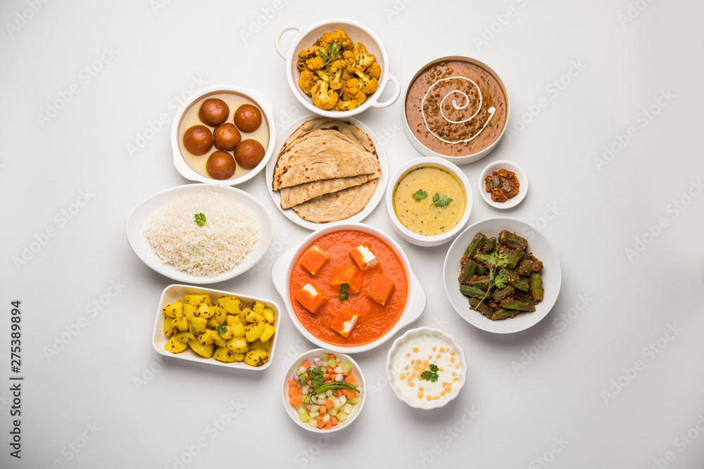 Assorted Indian food like paneer butter masala, dal, roti, rice, sabji ...