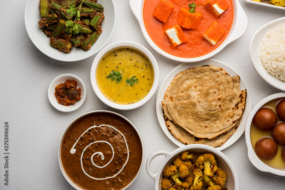 Assorted Indian food like paneer butter masala, dal, roti, rice, sabji ...