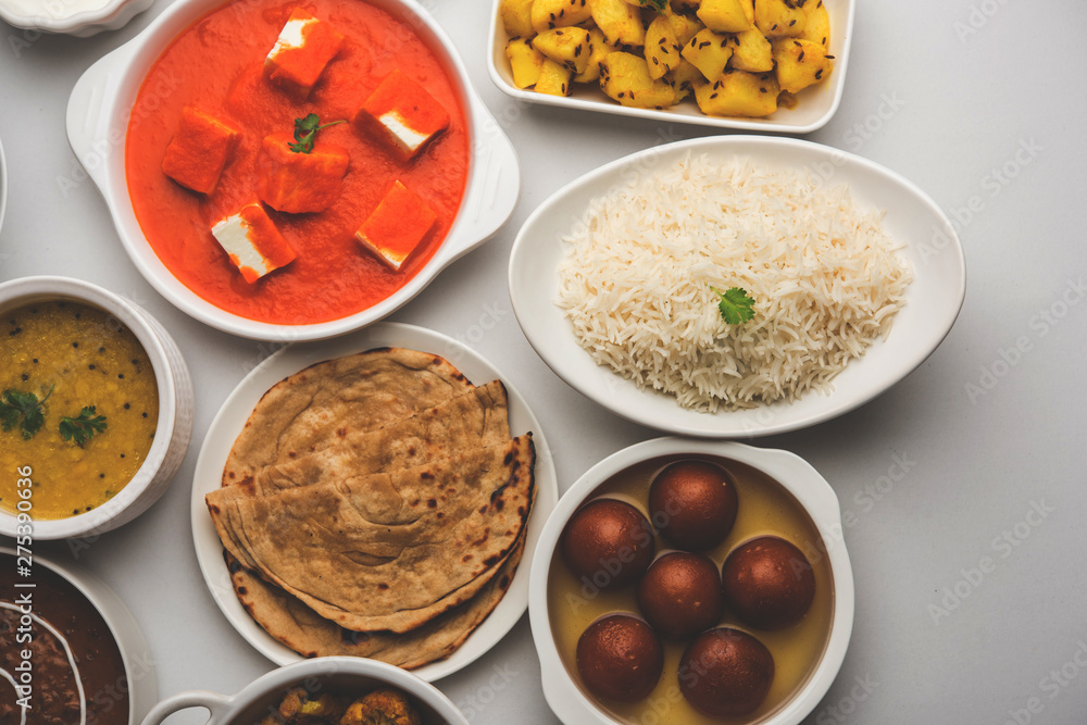 Assorted Indian food like paneer butter masala, dal, roti, rice, sabji ...