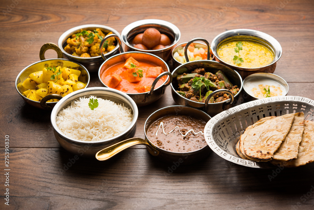 Assorted Indian food like paneer butter masala, dal, roti, rice, sabji ...
