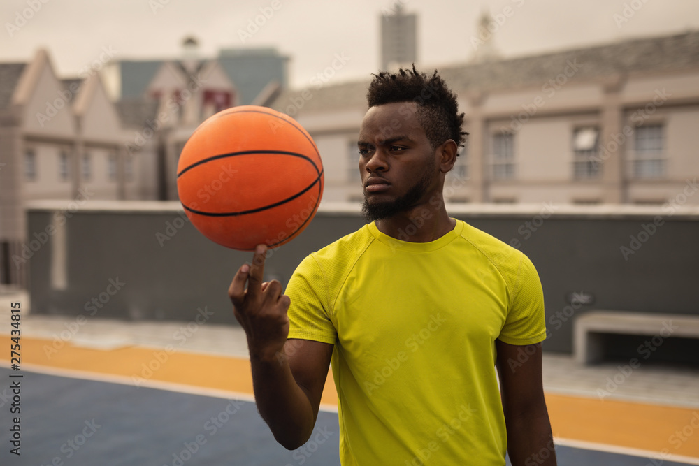 Basketball player balancing ball on finger at basketball court Stock ...