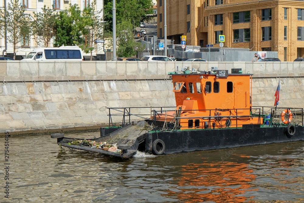 River cleaning boat collects garbage on water surface of river.Trash ...