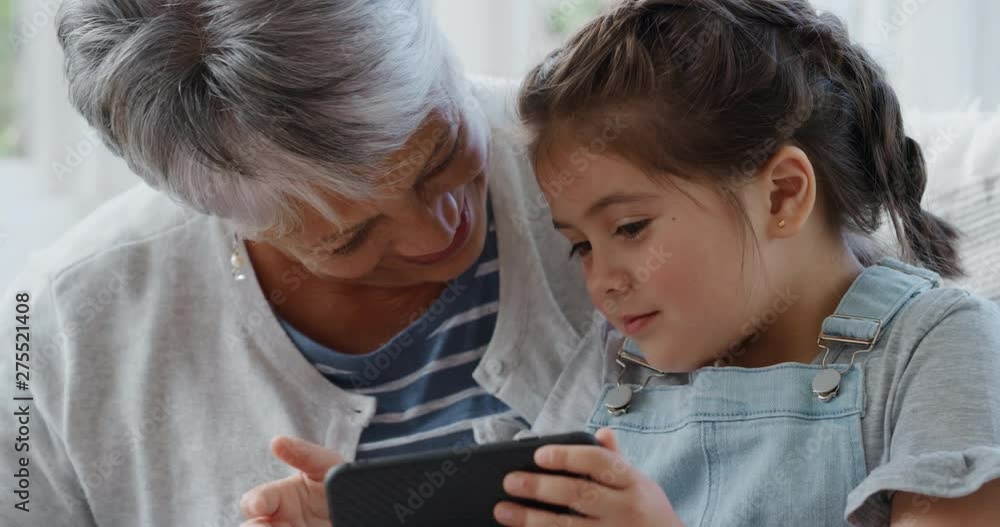 little girl showing grandmother how to use smartphone teaching granny ...