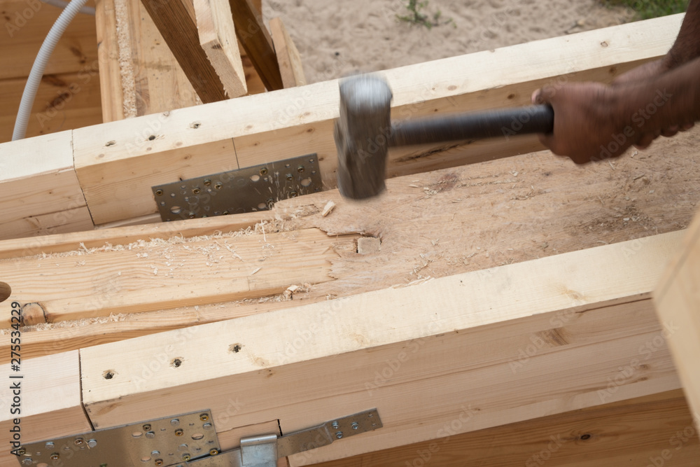 Workers, carpenters, hammering wooden pins with a sledgehammer. Details ...