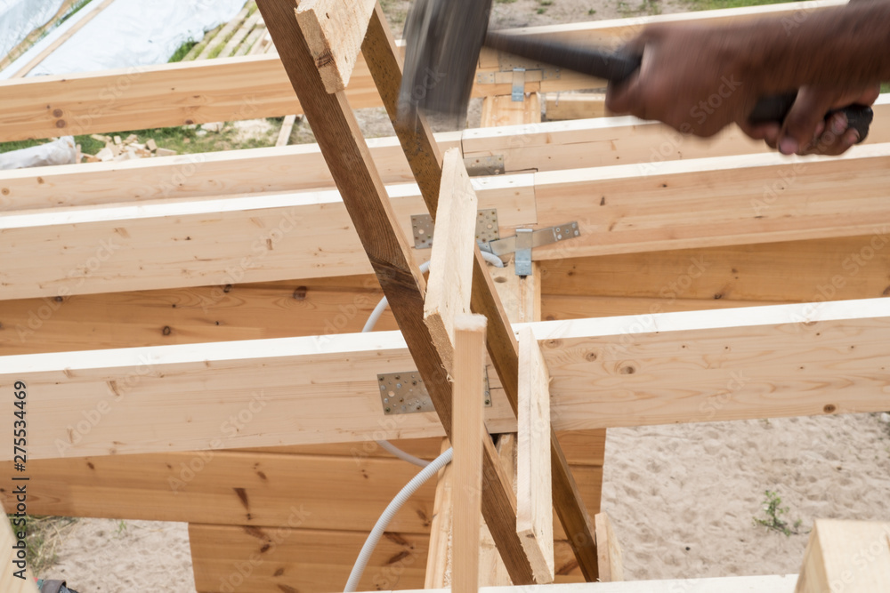 Workers, carpenters, hammering wooden pins with a sledgehammer. Details ...