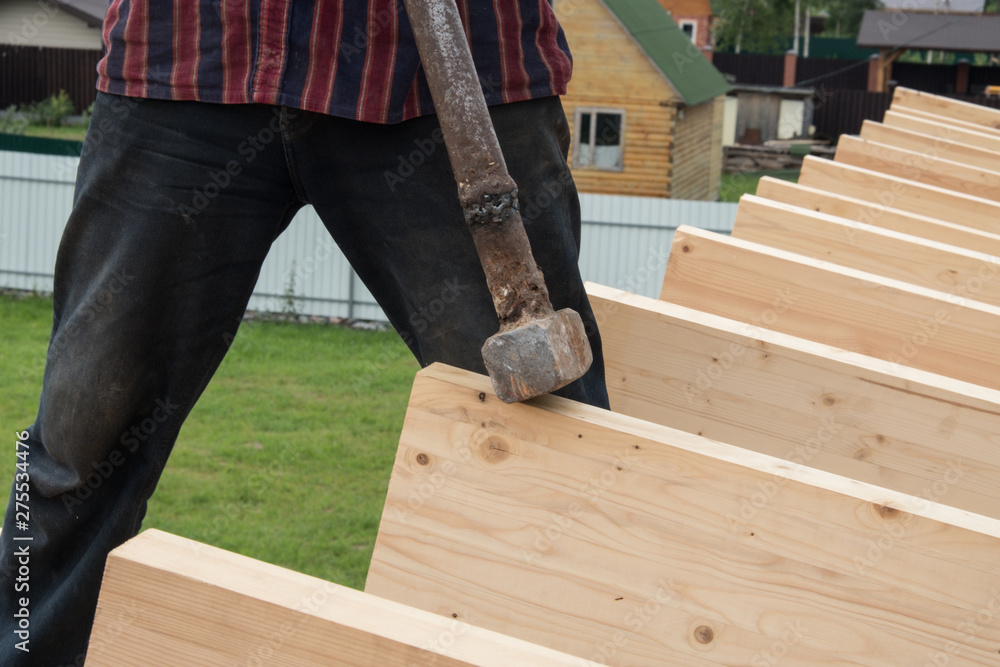 Foto Stock Workers, carpenters, hammering wooden pins with a ...
