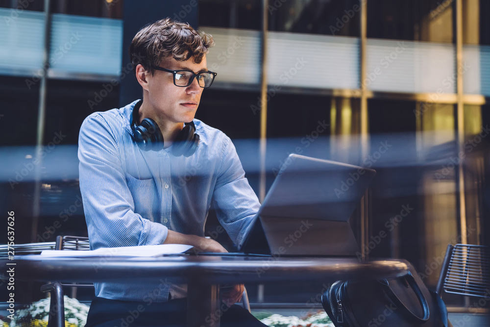 Foto de Young man skilled office worker using touch pad during break at ...