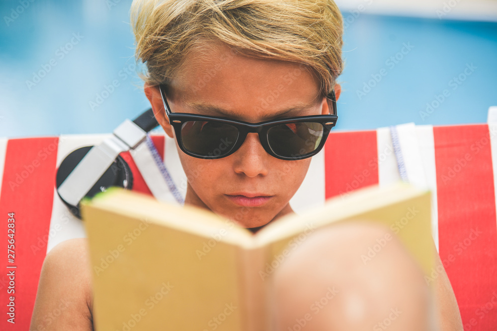 Sad young boy reading a book on a sunny day after end of school Home ...