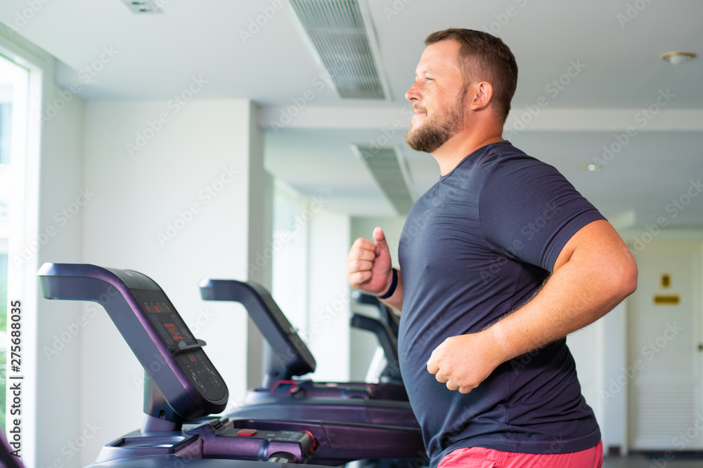 chubby man walking on running track, warming up on gym treadmill. Stock ...