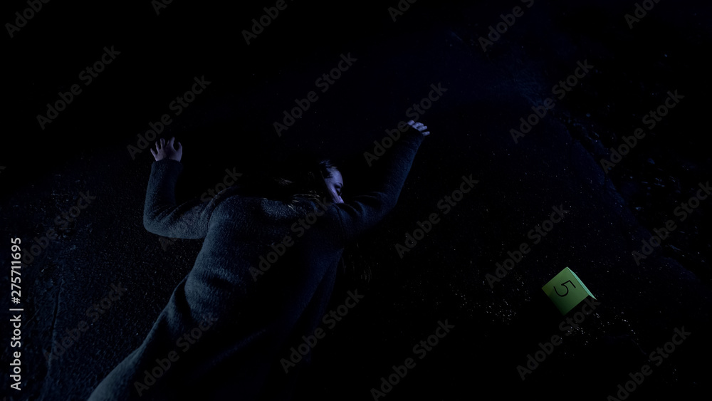 Dead person lying on ground, template with evidence mark standing at ...