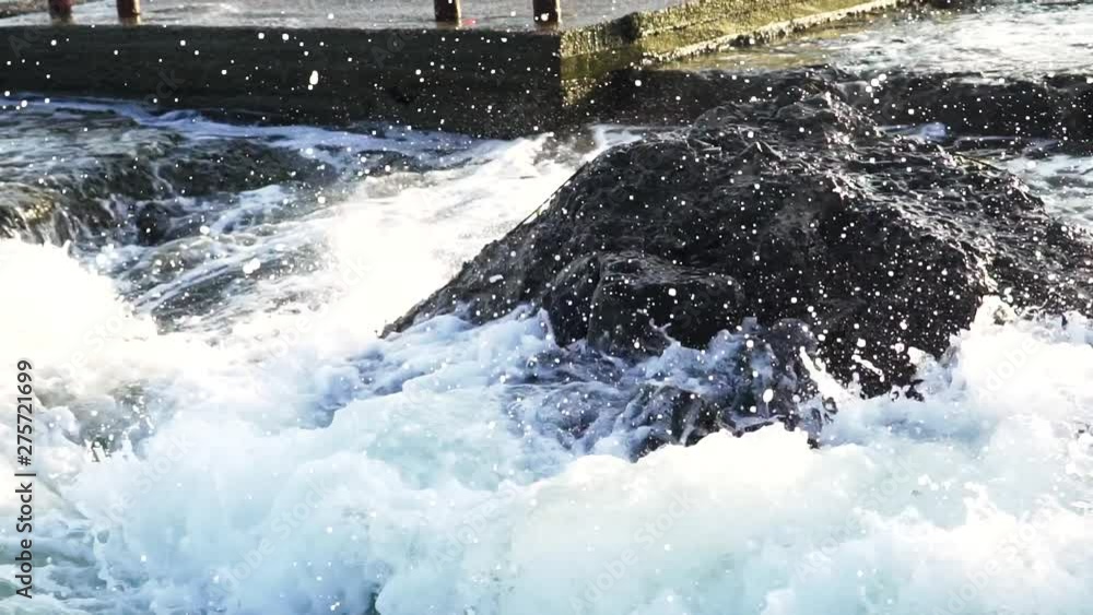 Sea waves hit the rocks and fly around with a lot of splashes. Big wave ...