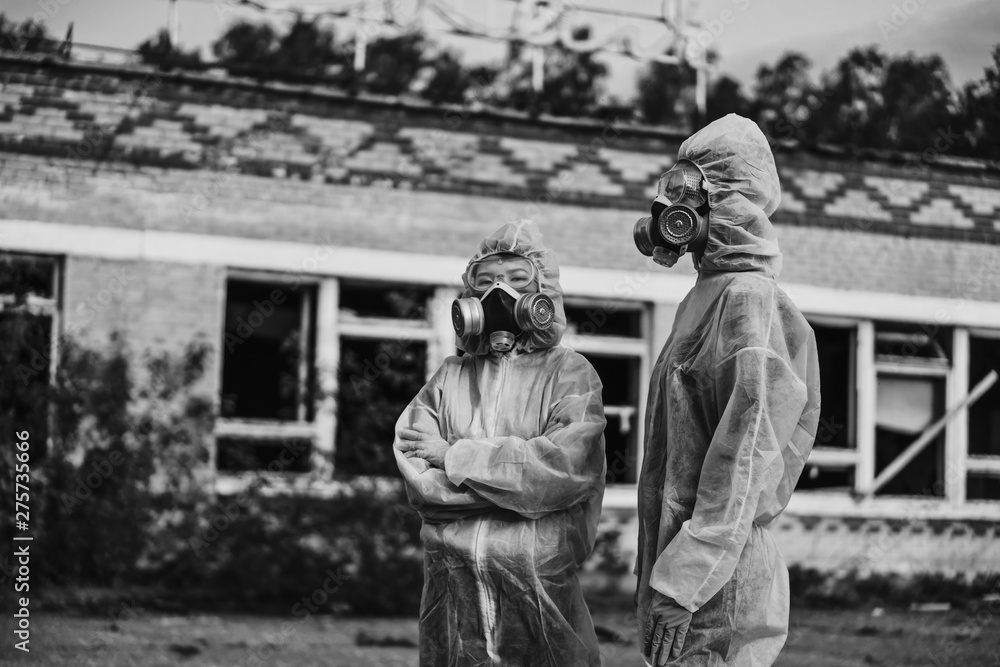 Two scientists put on a respirator and a radiation protective suit ...
