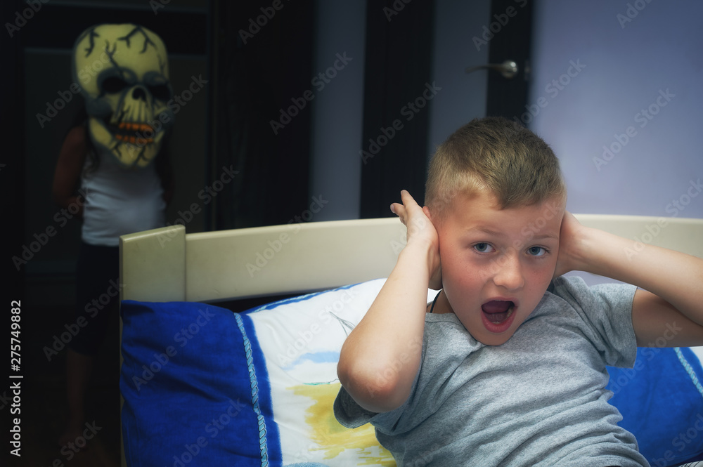 Frightened boy at night in bed. A terrible night dream of a child ...
