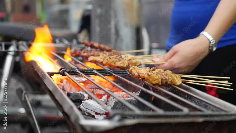 Traditional grilled meat on sticks cooked at street local market. Satay ...