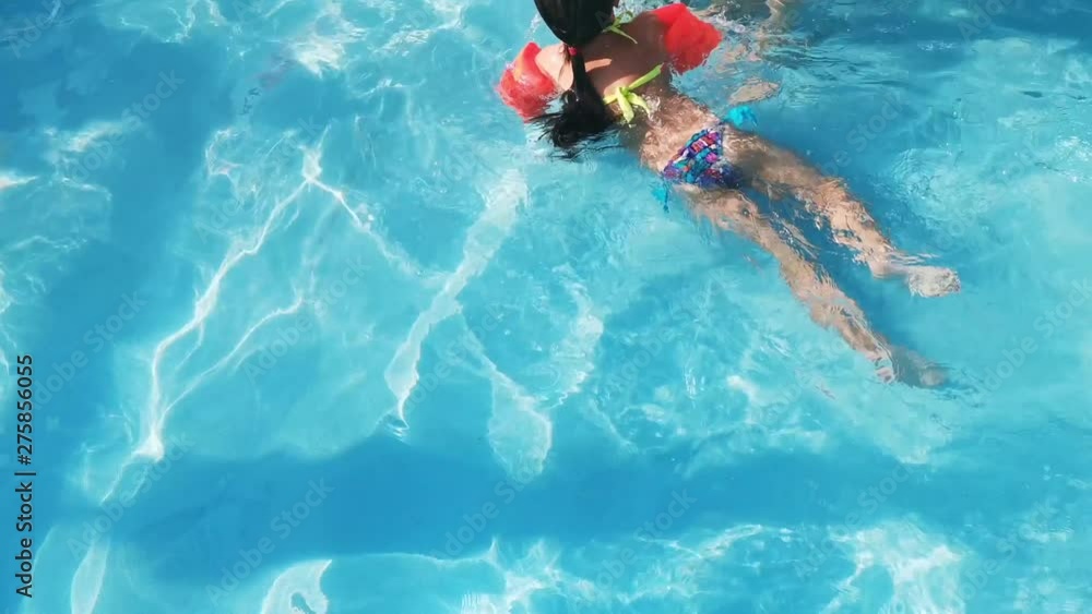 Little girl playing in outdoor swimming pool jumping into water on ...
