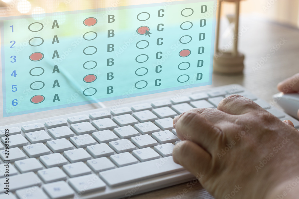 Dry hand of adult student using white keyboard on table to do test ...
