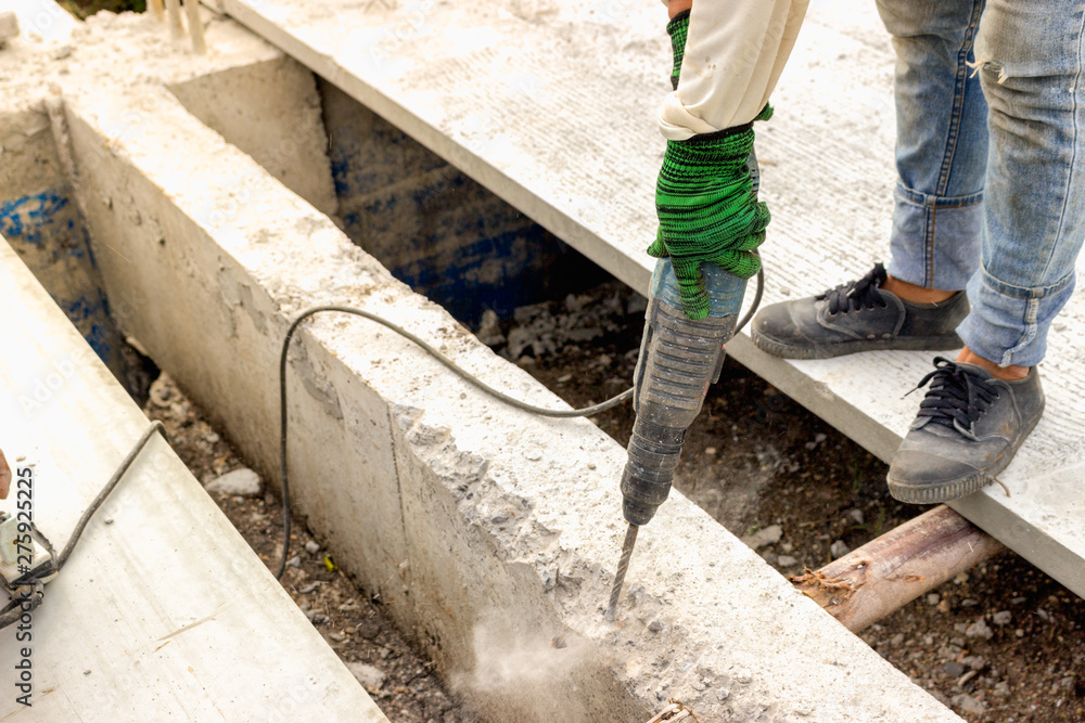 Man are using punching machines to penetrate the excess cement of the ...