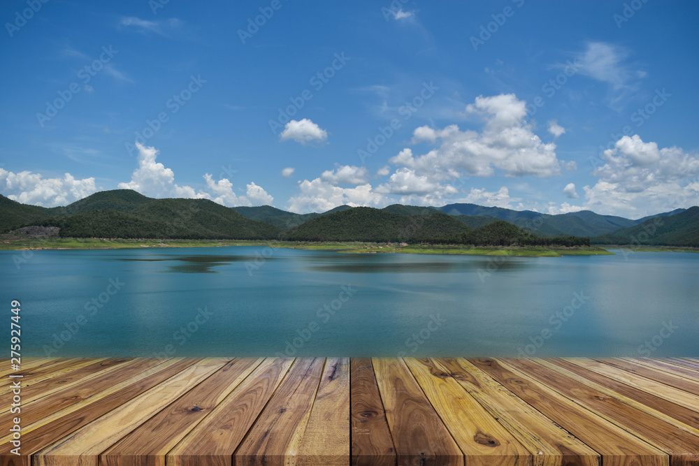 Perspective empty wood table on top over dam and mountain with blue sky ...