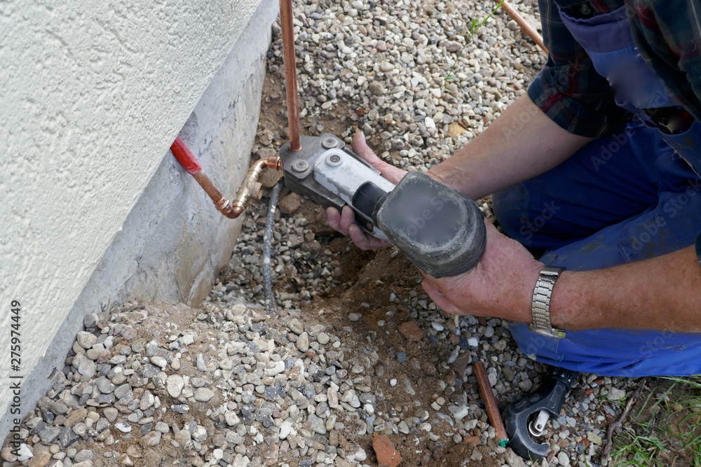 Installation of an outdoor tap. Installer closes water pipe with ...