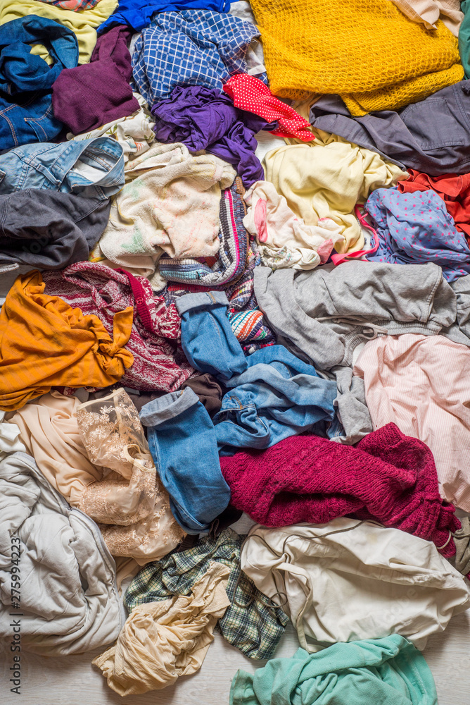 pile of used clothes on a light background. Second hand for recycling ...