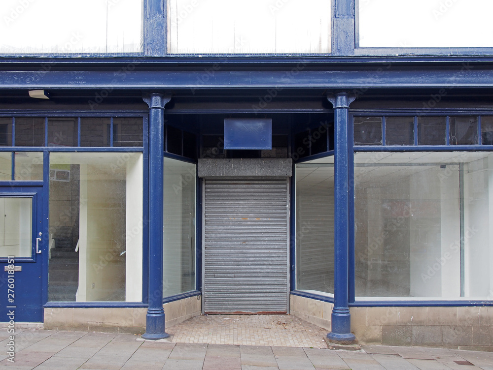 the facade of an old abandoned shop painted blue and white with empty ...