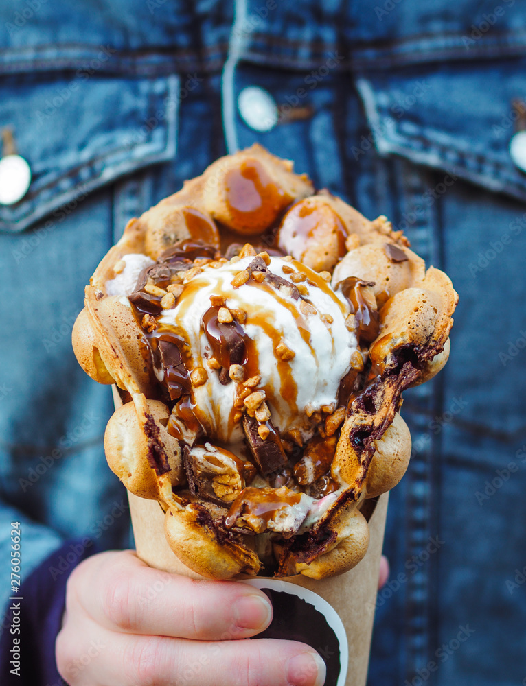Hong Kong waffles in female hand. Girl in denim jacket hold delicious ...