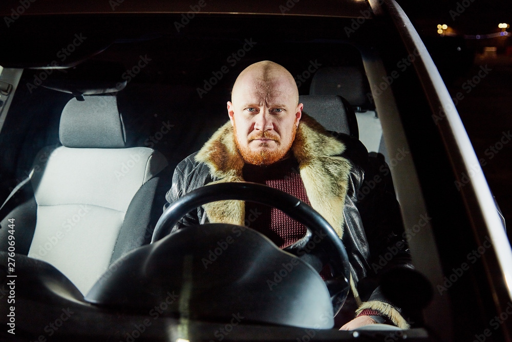 Male driver in a leather jacket in the car in the dark. Night photo ...