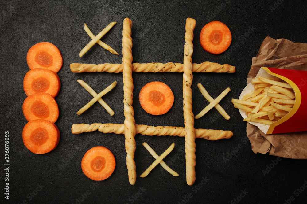 Fotka „Game of tic tac toe of french fries and carrot. Choosing healthy ...