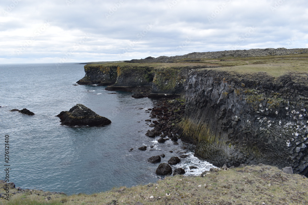 Hiking trail from Anarstapi to Hellnar with the raw ocean und big rocks and mountains in the ...