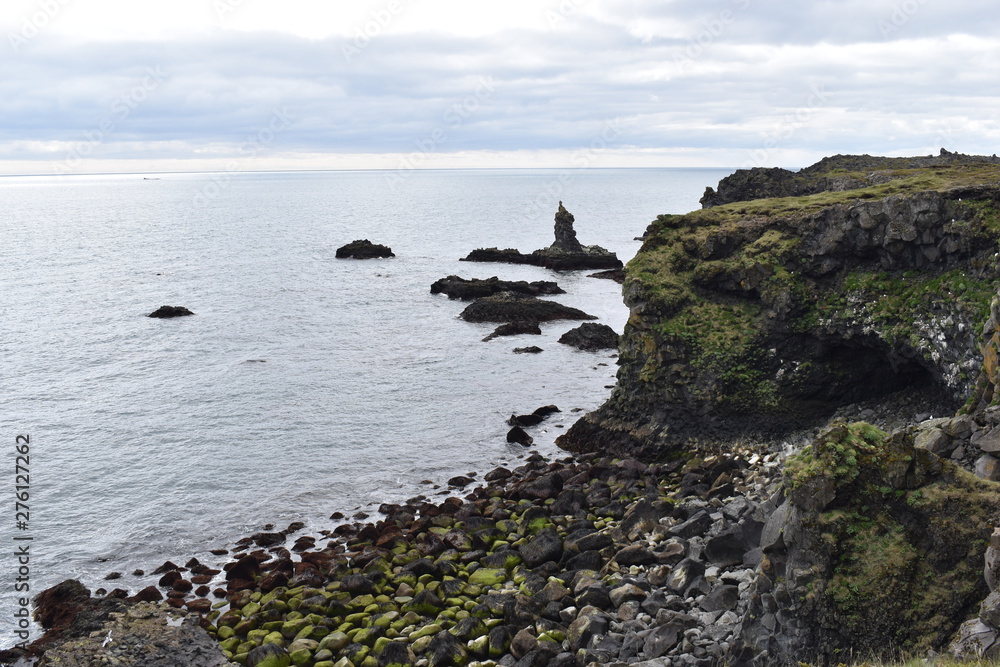 Hiking trail from Anarstapi to Hellnar with the raw ocean und big rocks and mountains in the ...