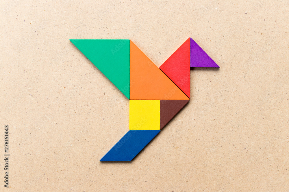 Color tangram puzzle in flying bird shape on wood background Stock ...