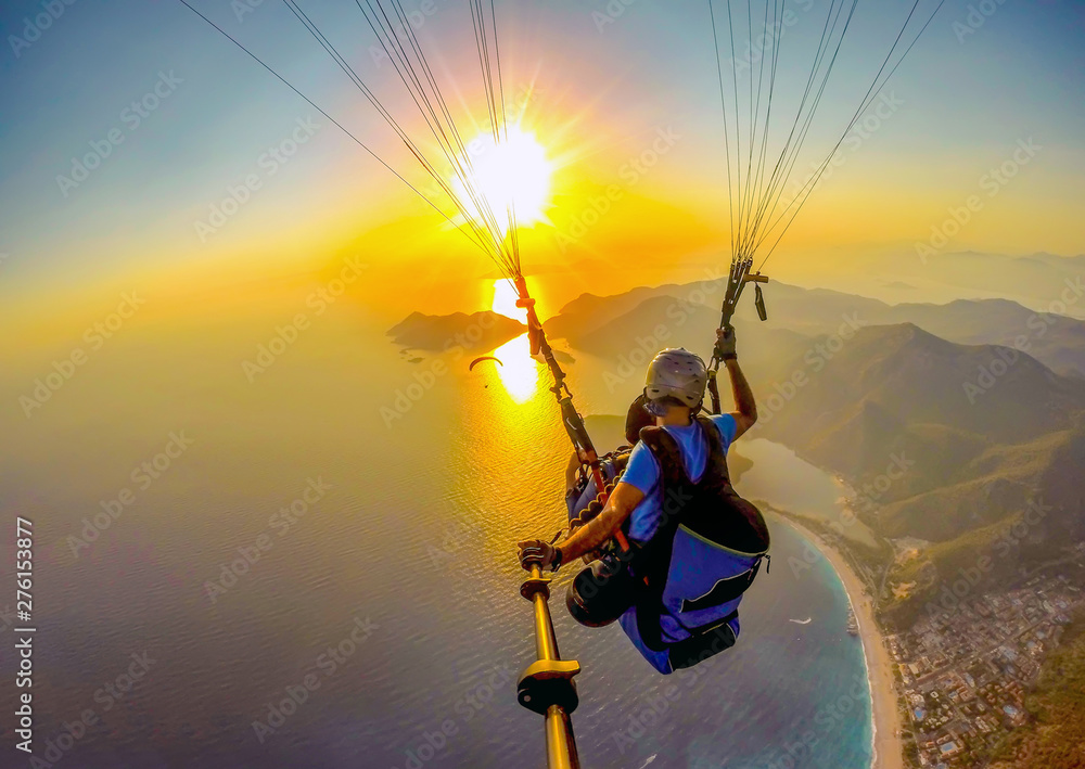 Paragliding in the sky. Paraglider tandem flying over the sea with blue ...