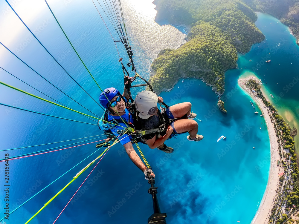 Paragliding in the sky. Paraglider tandem flying over the sea with blue ...