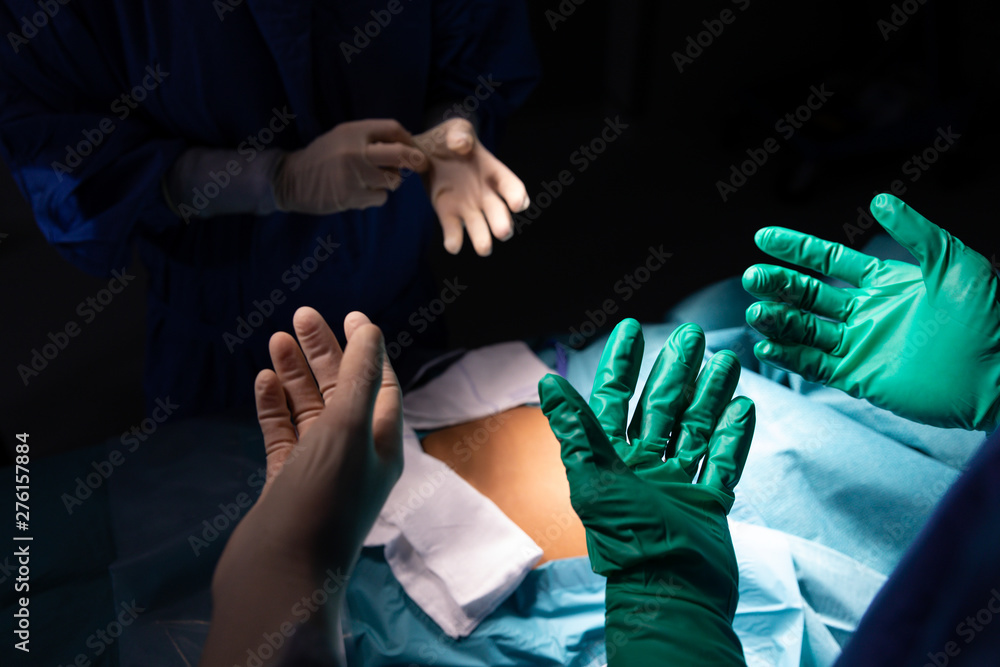 Surgeons wearing surgical gloves in operating room Stock Photo | Adobe ...