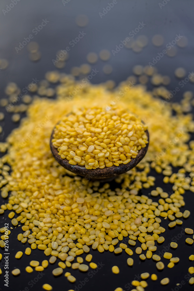 Unskinned split mung dal or moong dal in a black colored clay bowl on ...