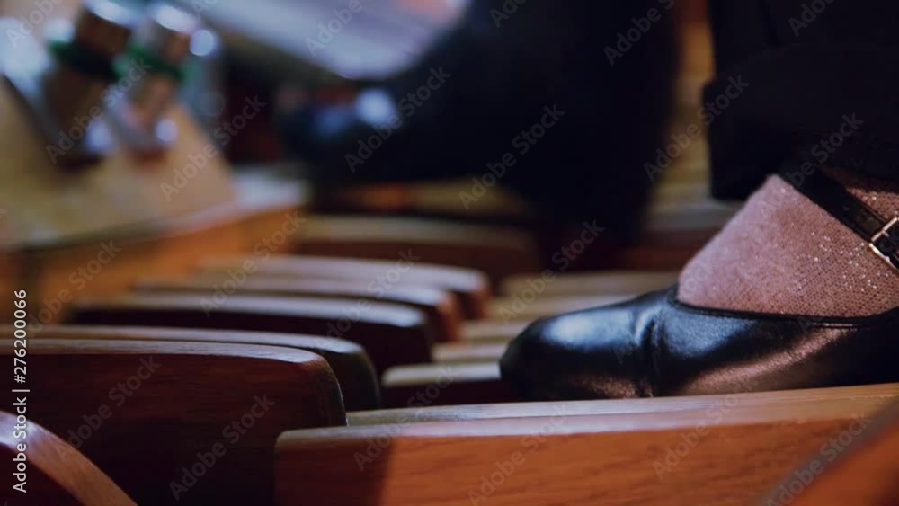 Slow motion close up view of female feets pushing the pipe organ pedals ...