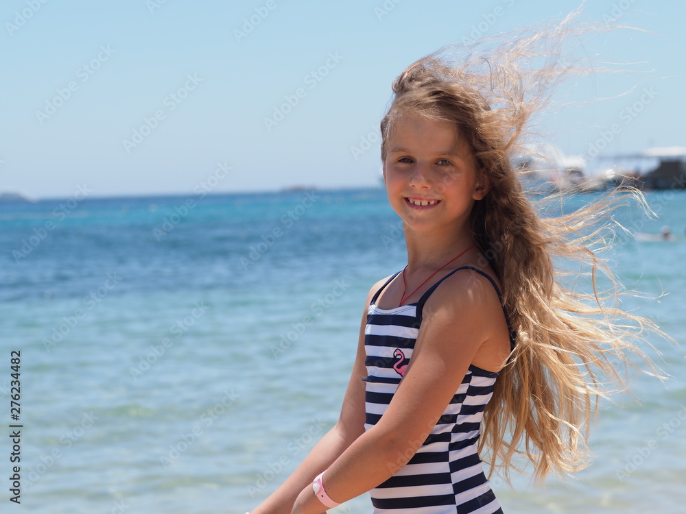 A portrait of a European girl of 9 years old whose wind blows long hair ...