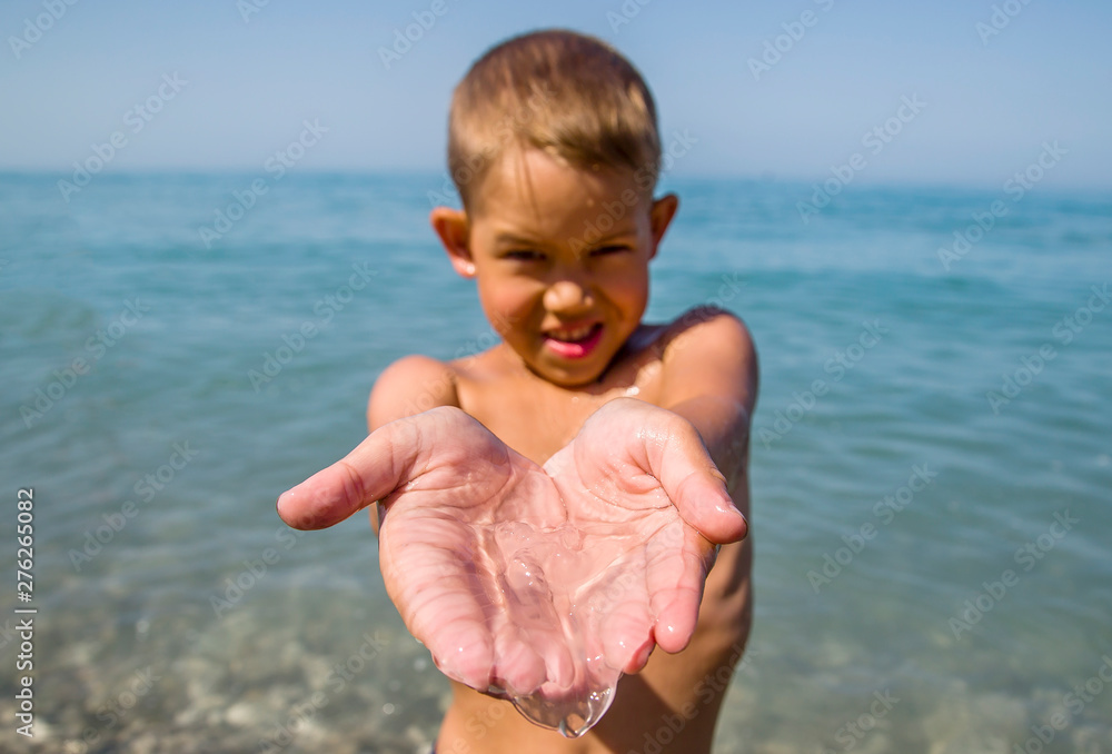 boy on the beach holding a jellyfish, background and face blurred Stock ...