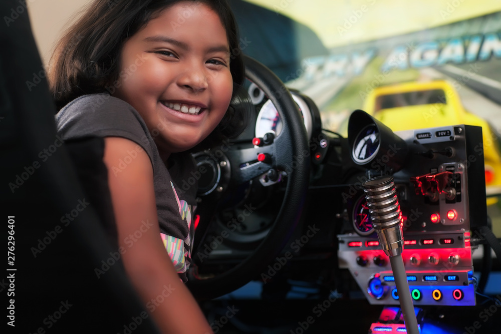 A cute girl with a big smile playing a driving game in a realistic ...