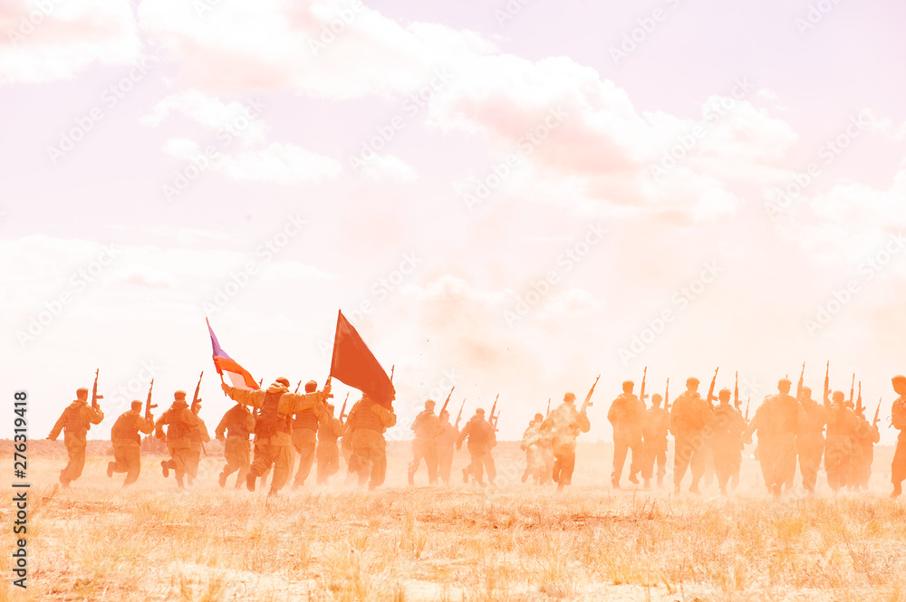 Silhouettes of retreating soldiers hold weapons in smoke on sunset ...