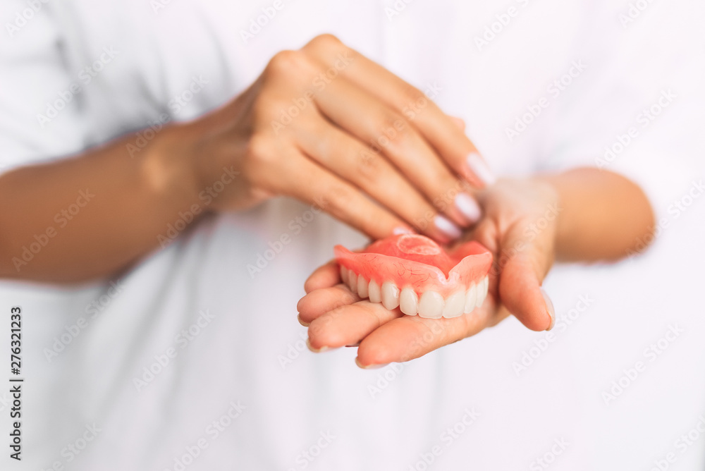 The dentist is holding dentures in his hands. Dental prosthesis in the ...