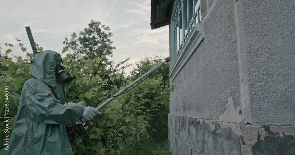 Man in the WWII Hazmat suit and gas mask checking the exterior of an ...