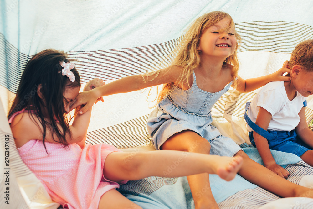 Horizontal image of happy children sitting on the blanket, playing ...