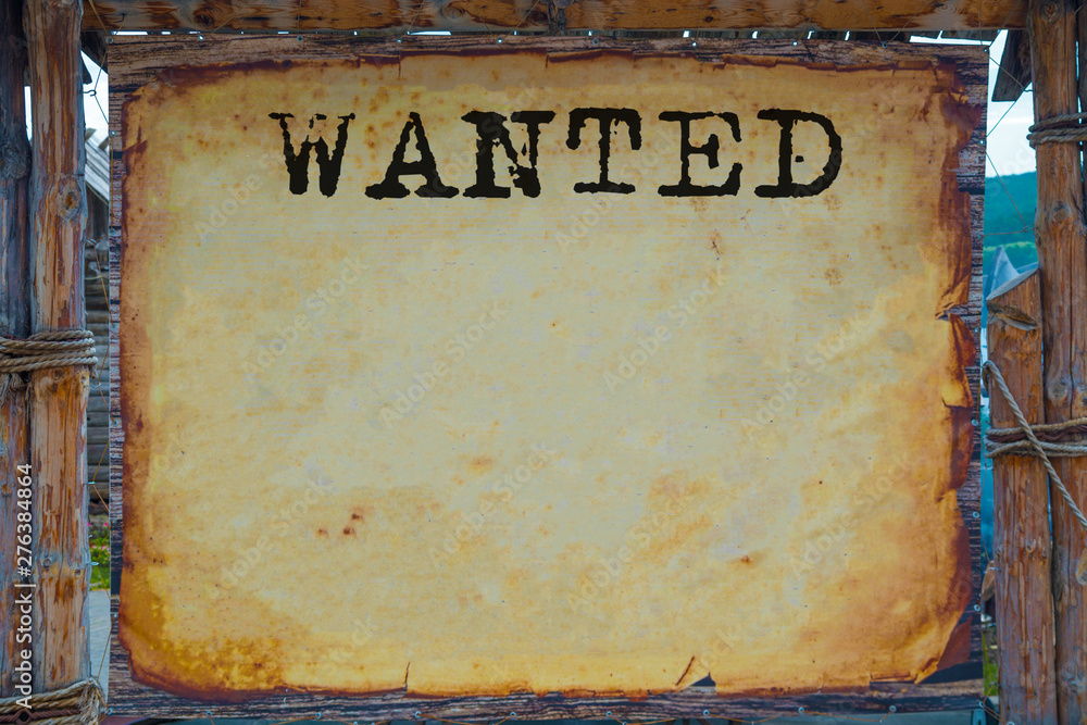 Old wanted banner, paper poster stretched on a frame of trees. Copy ...