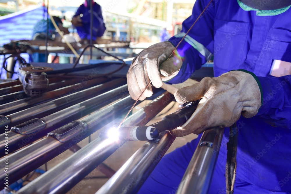 The welder is welding the plate to the pipe with Tungsten Inert Gas ...