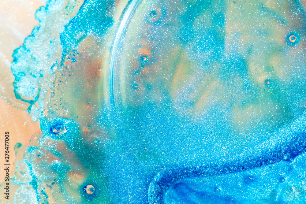 Macro shot suspension of particles in a colored emulsion over backlit ...