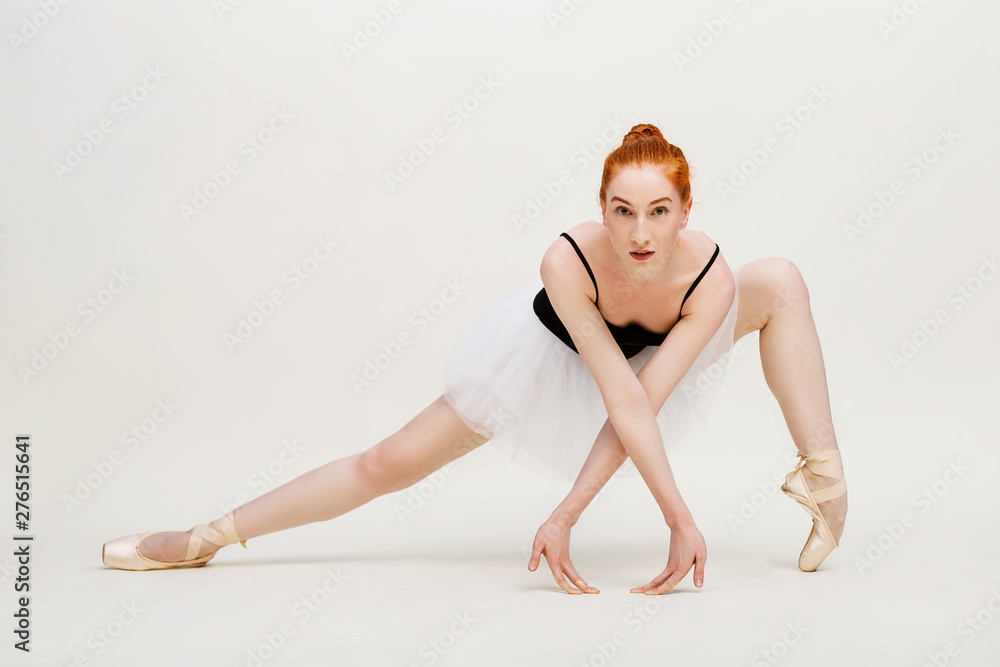 Modern ballet dancer exercising in full body on light grey studio ...