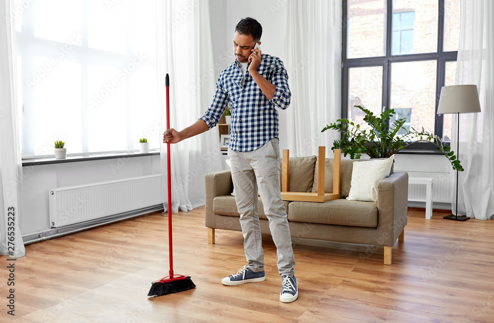 cleaning, housework and housekeeping concept - indian man with broom ...