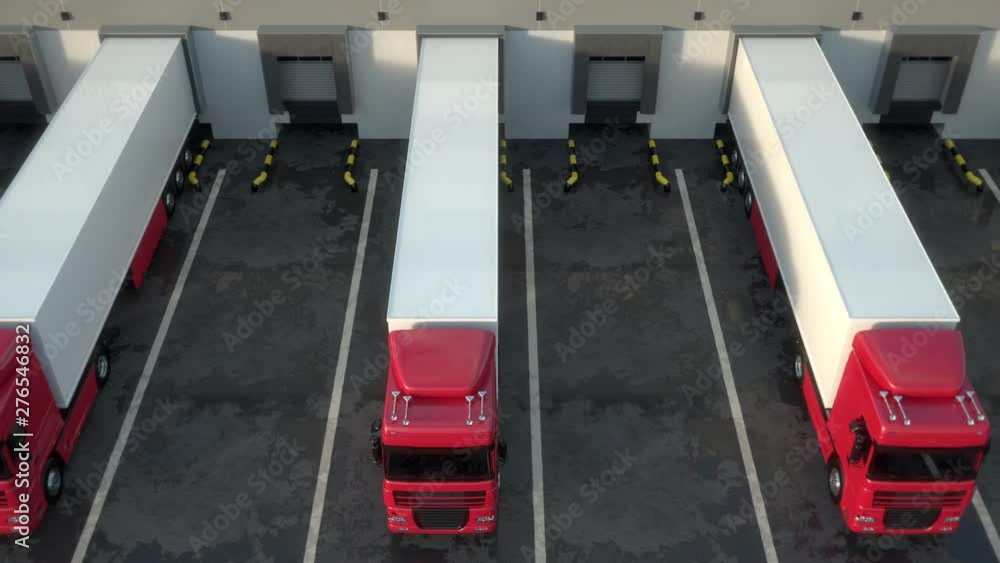 Red semi trucks loading and unloading goods at warehouse dock. Aerial ...