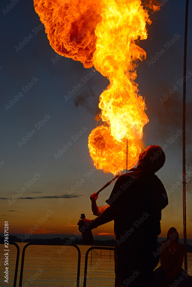 fire breather producing a large flame against dark sky Stock Photo ...